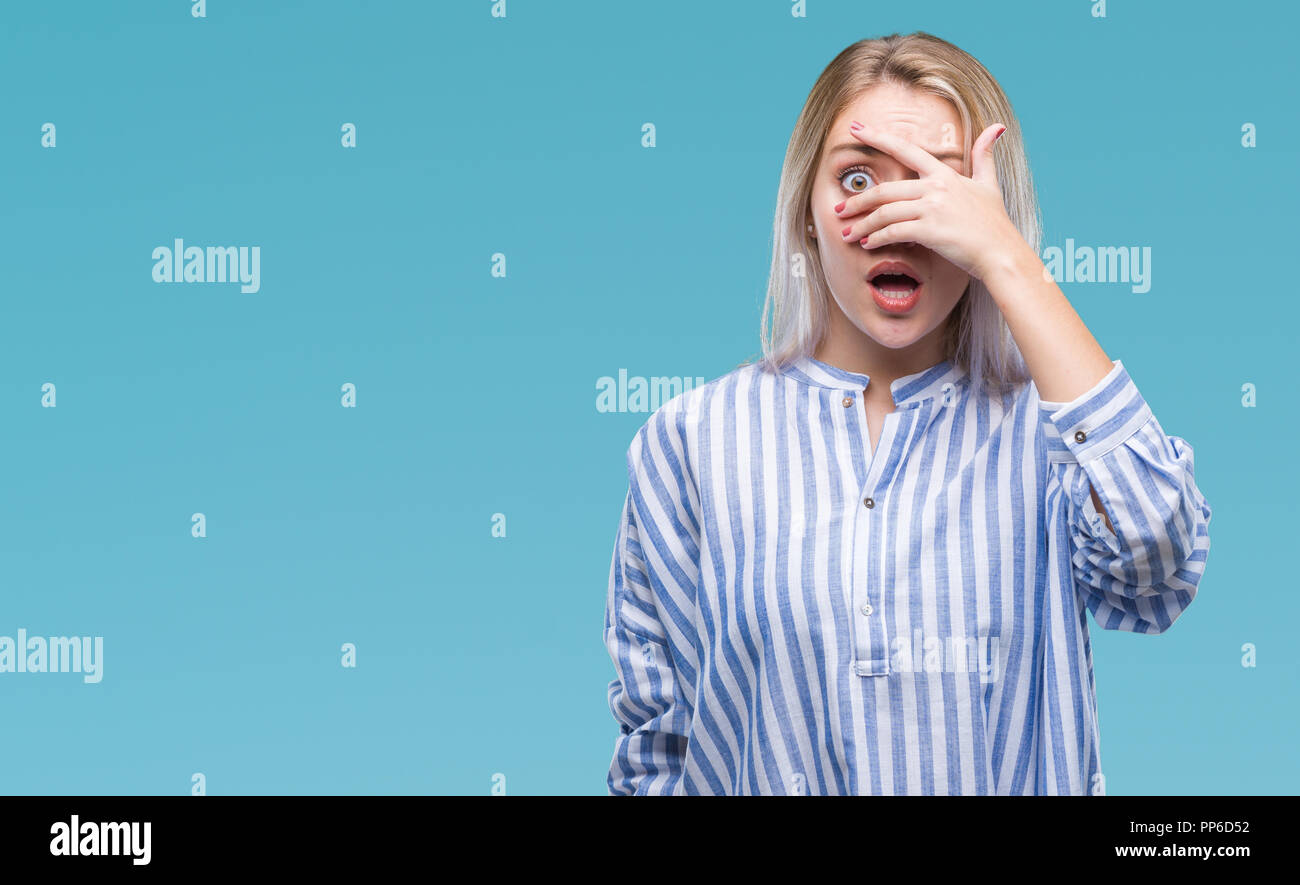 Young blonde woman over isolated background peeking in shock covering ...