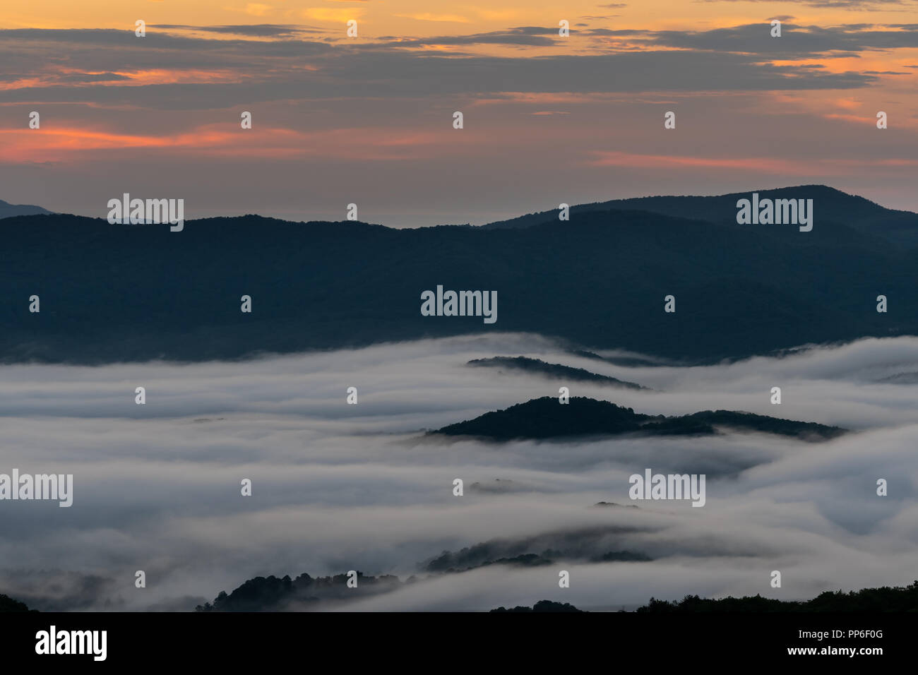 Pink Morning Light in Sky with Mountain Island Through Clouds in the ...