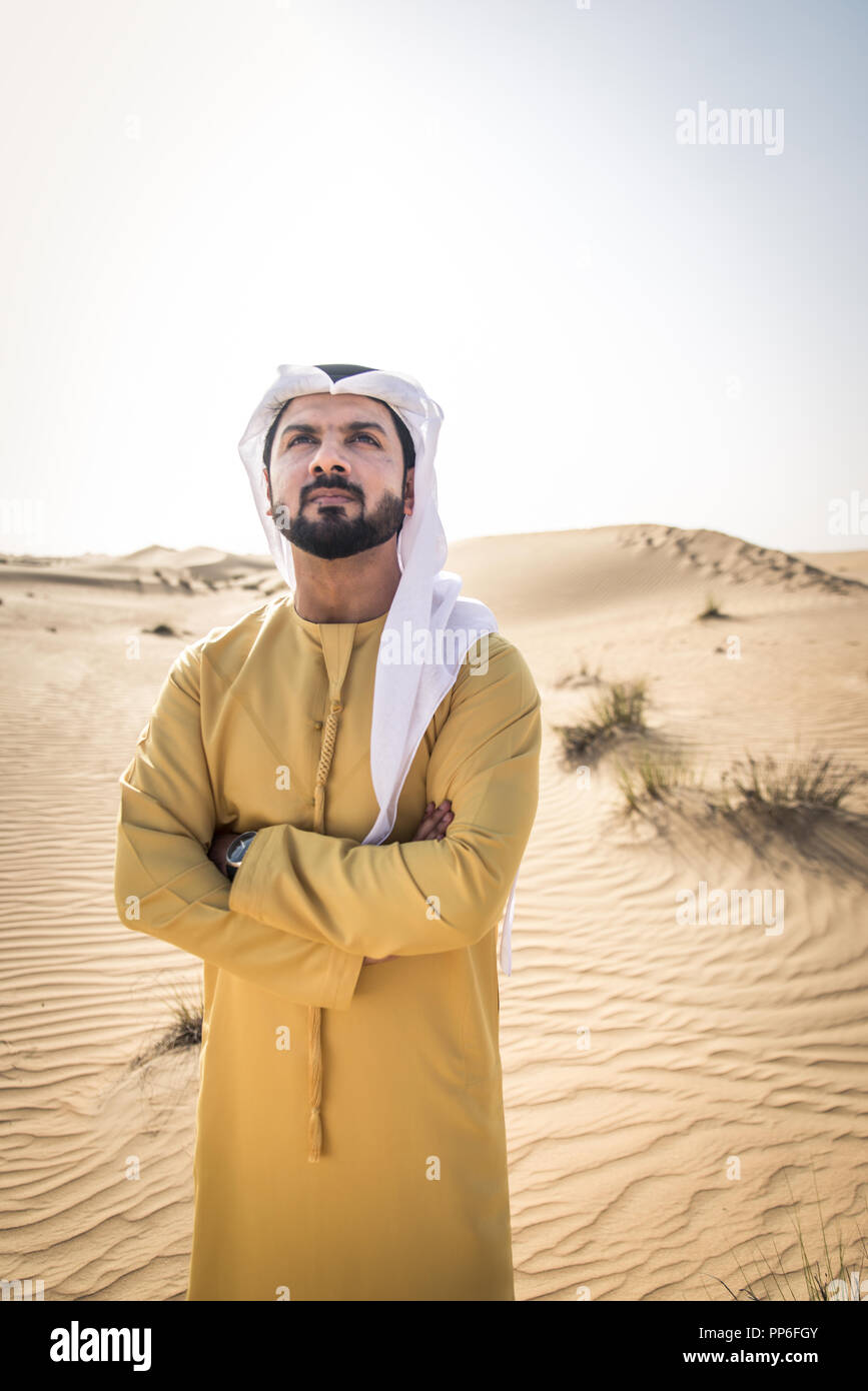 Handsome arabian man with traditional dress in the desert of Dubai ...