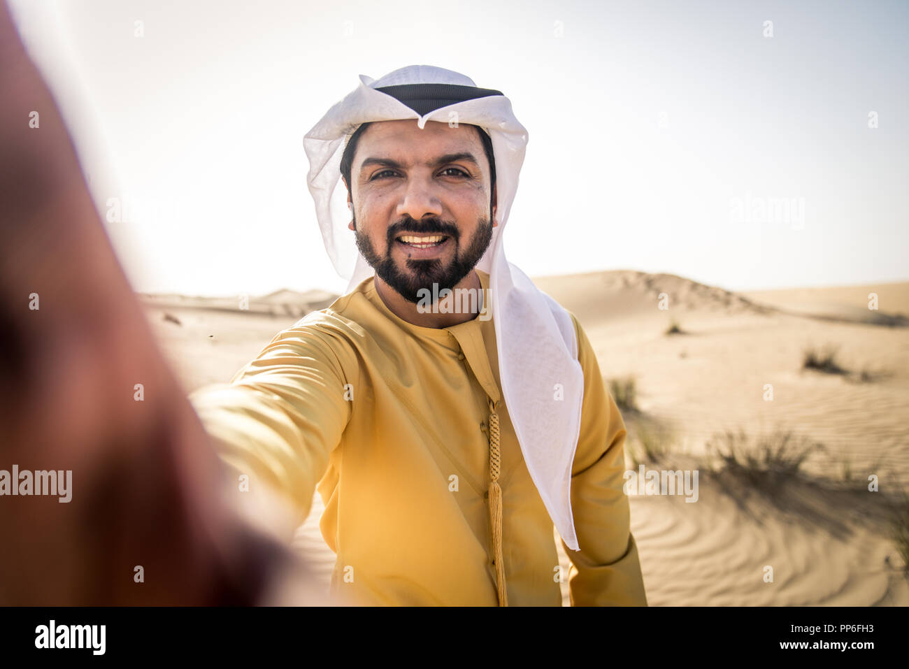 Handsome arabian man with traditional dress in the desert of Dubai ...