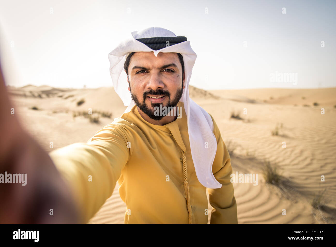 Handsome arabian man with traditional dress in the desert of Dubai ...