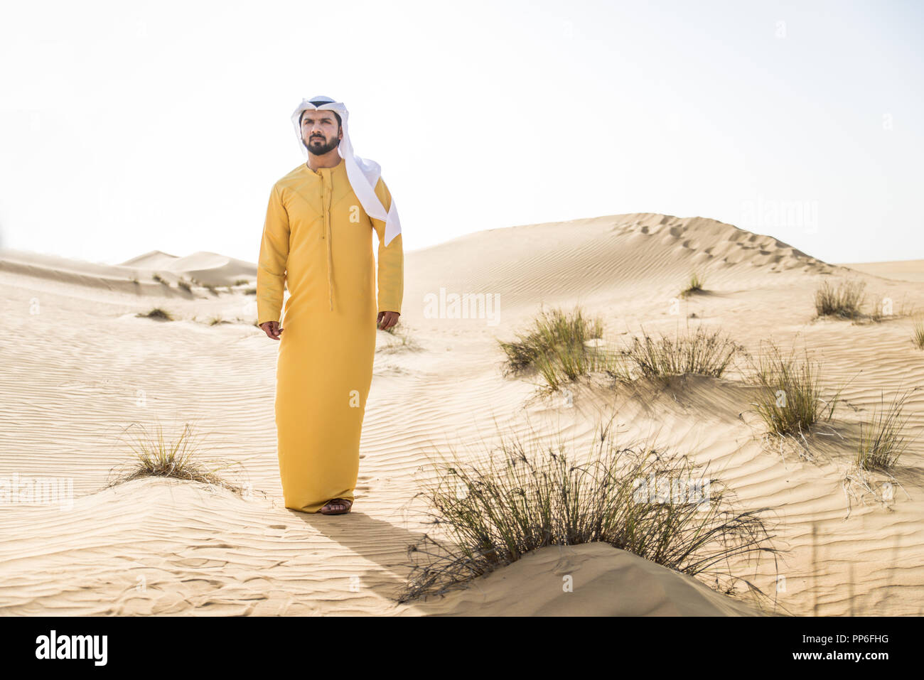 Handsome arabian man with traditional dress in the desert of Dubai ...