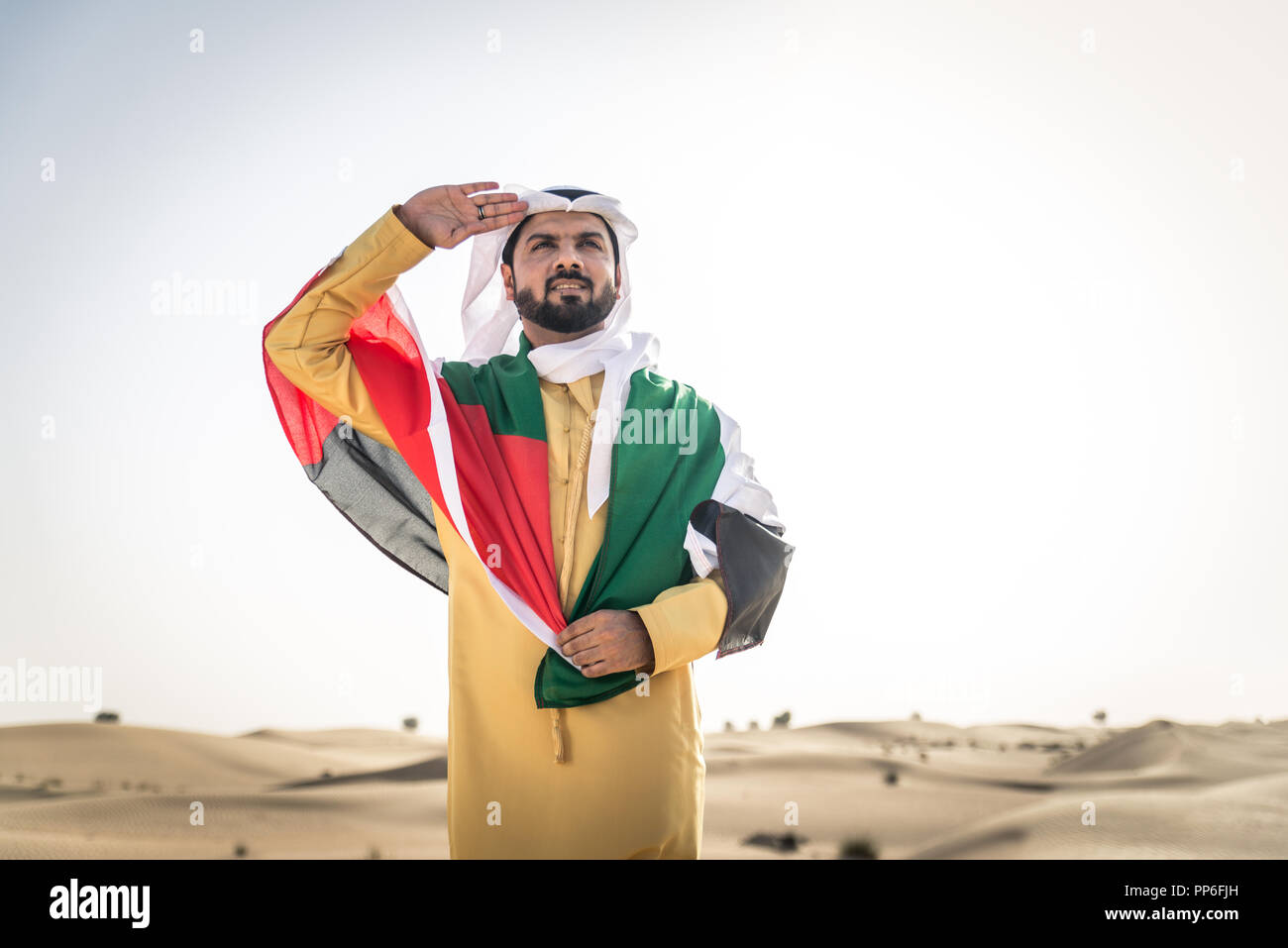 Handsome arabian man with traditional dress in the desert of Dubai ...