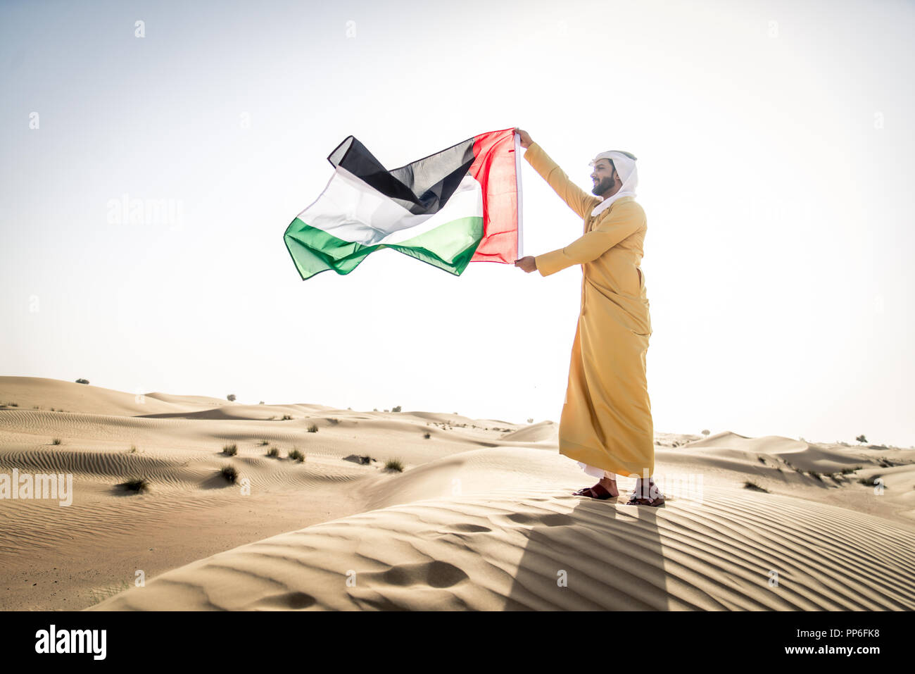 Handsome arabian man with traditional dress in the desert of Dubai ...