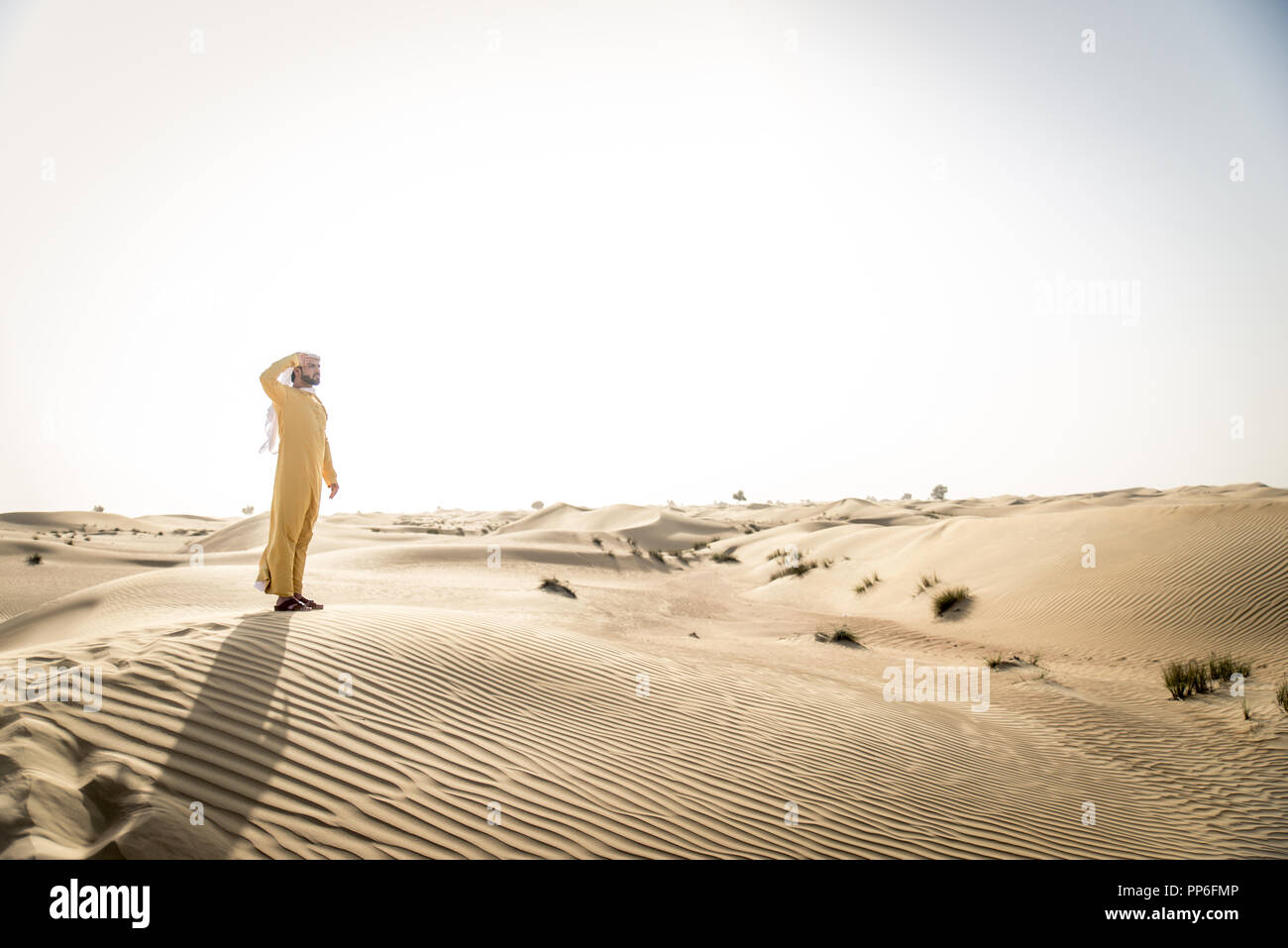Handsome arabian man with traditional dress in the desert of Dubai ...