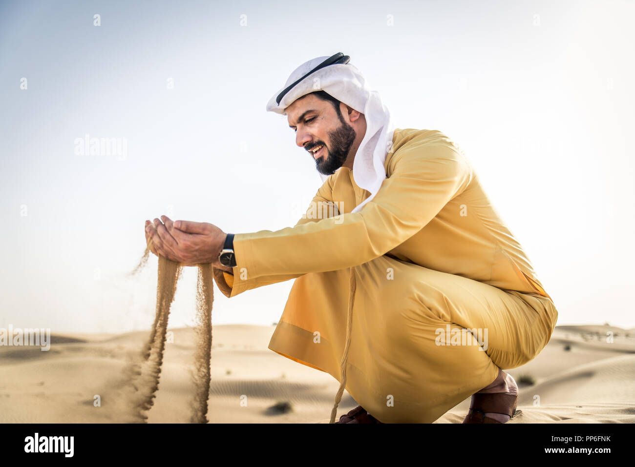 Handsome arabian man with traditional dress in the desert of Dubai ...