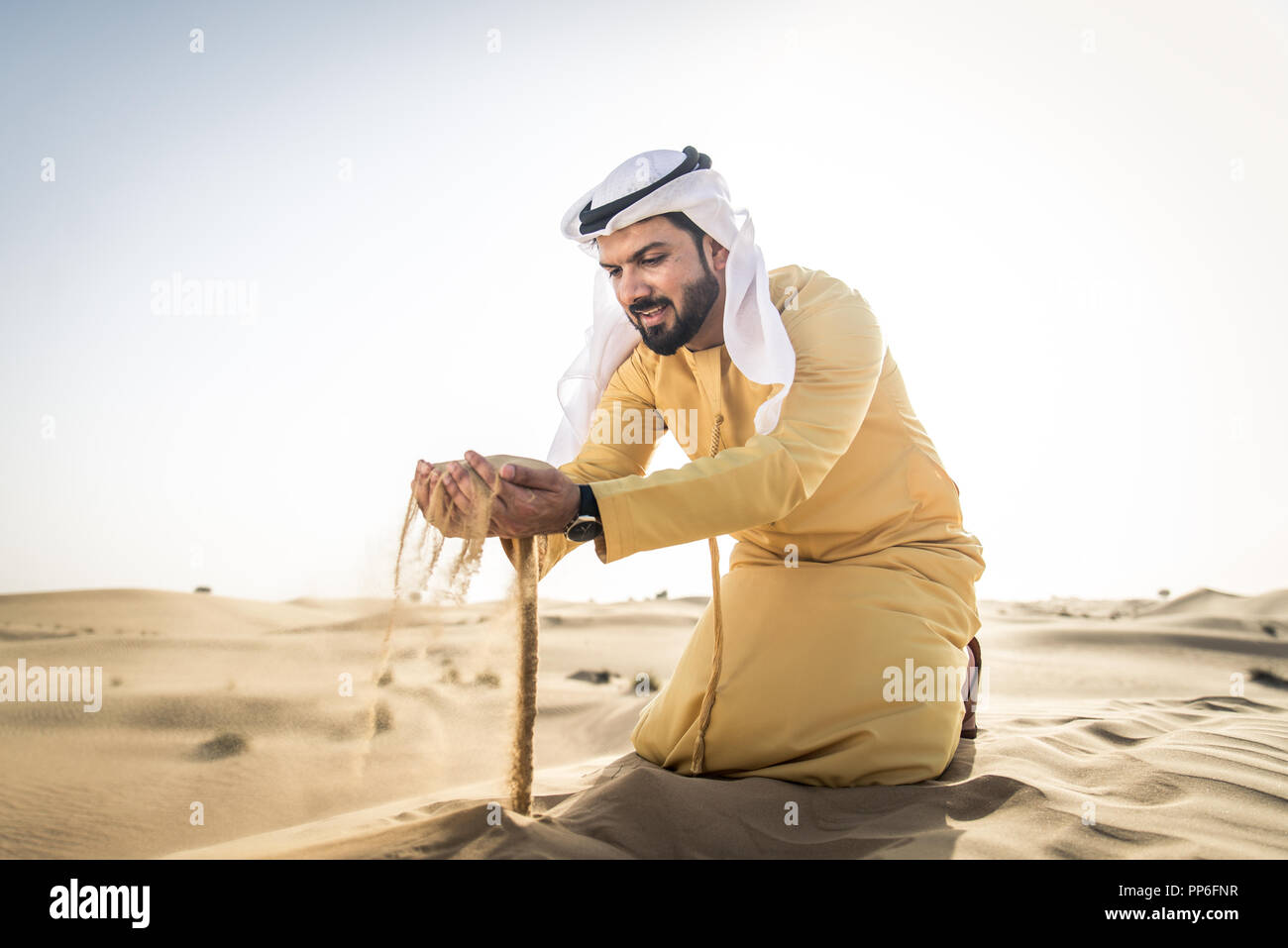Handsome arabian man with traditional dress in the desert of Dubai ...