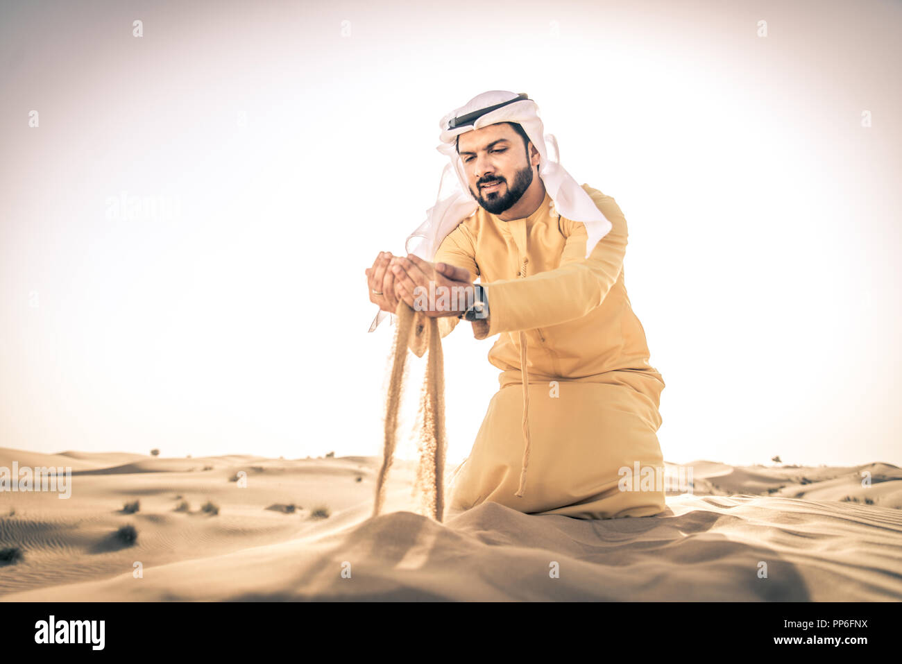 Handsome arabian man with traditional dress in the desert of Dubai ...