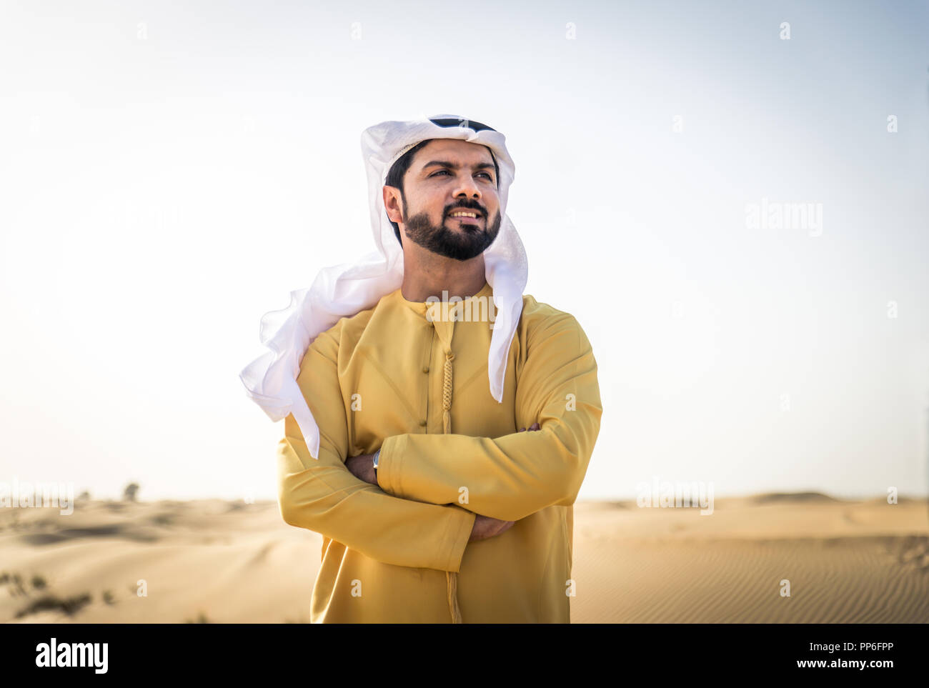 Handsome arabian man with traditional dress in the desert of Dubai ...