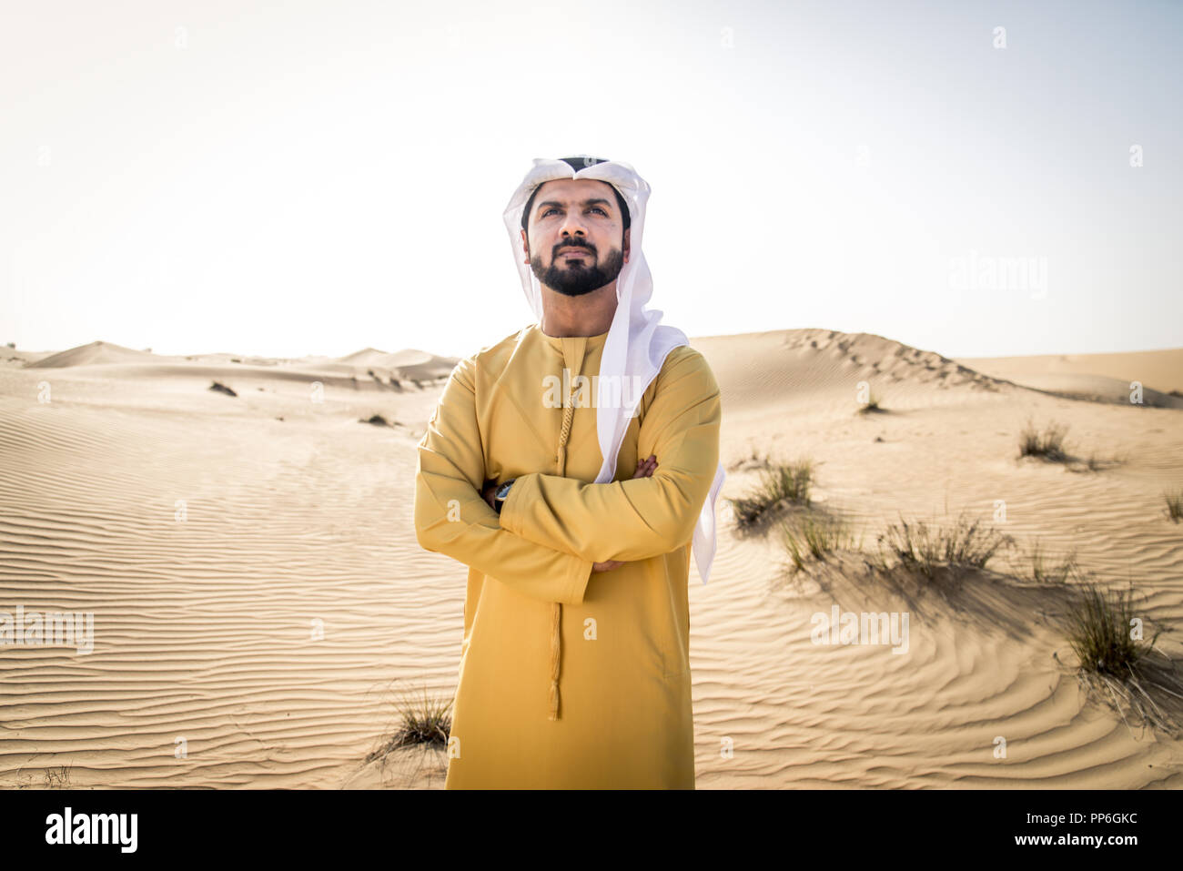 Handsome arabian man with traditional dress in the desert of Dubai ...
