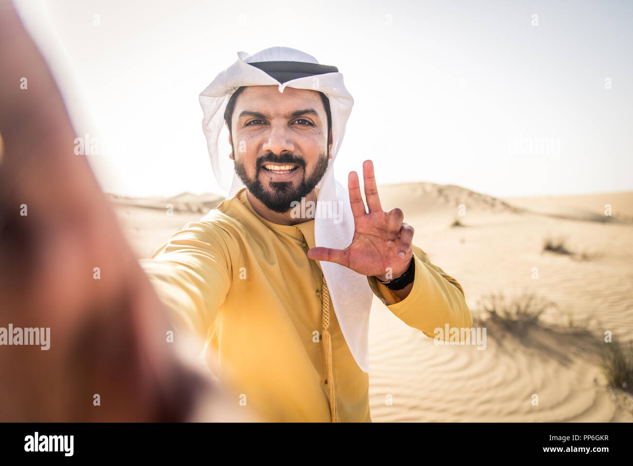 Handsome arabian man with traditional dress in the desert of Dubai ...