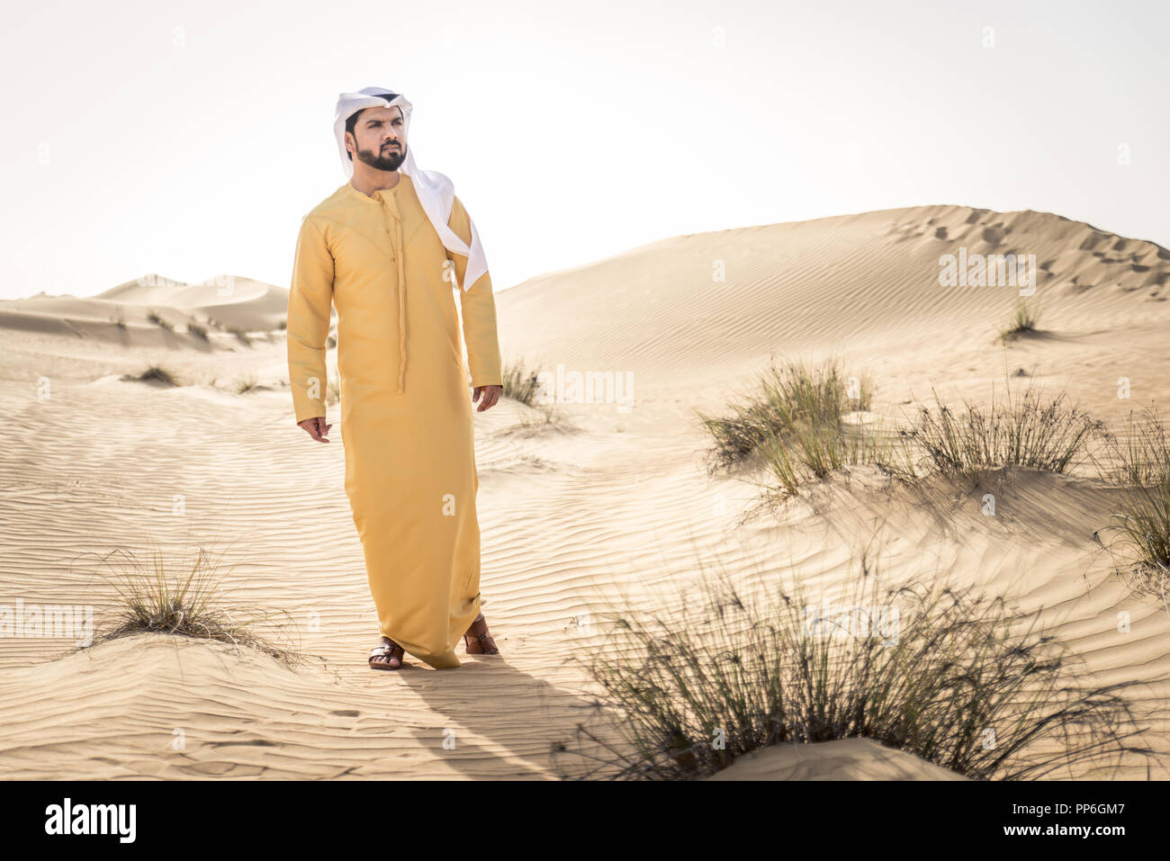 Handsome arabian man with traditional dress in the desert of Dubai ...
