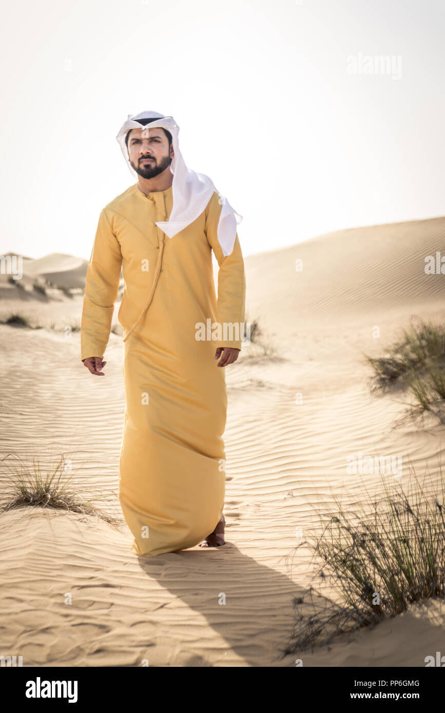Handsome arabian man with traditional dress in the desert of Dubai ...