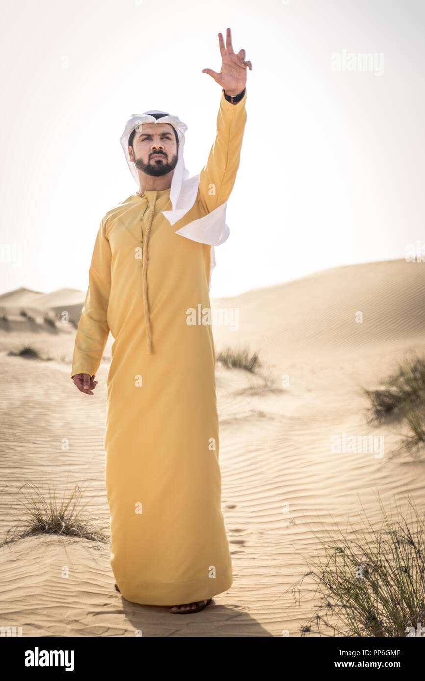 Handsome arabian man with traditional dress in the desert of Dubai ...