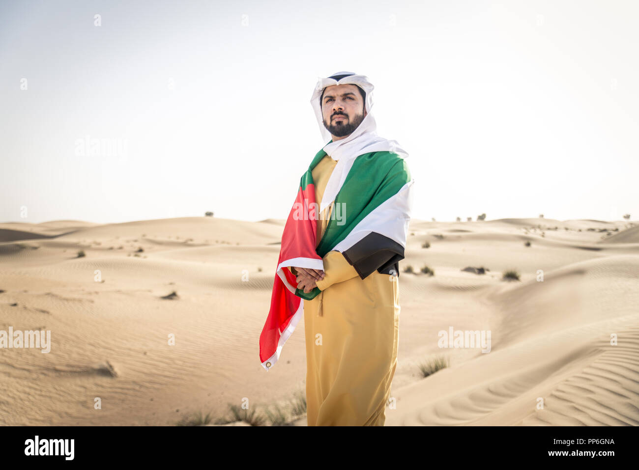 Handsome arabian man with traditional dress in the desert of Dubai ...