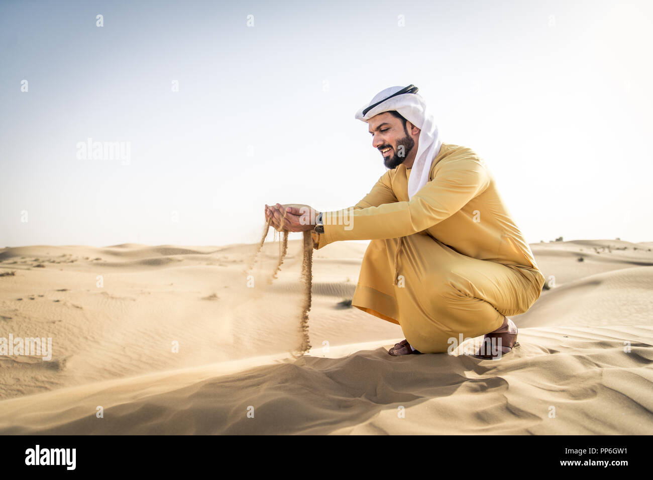 Handsome arabian man with traditional dress in the desert of Dubai ...