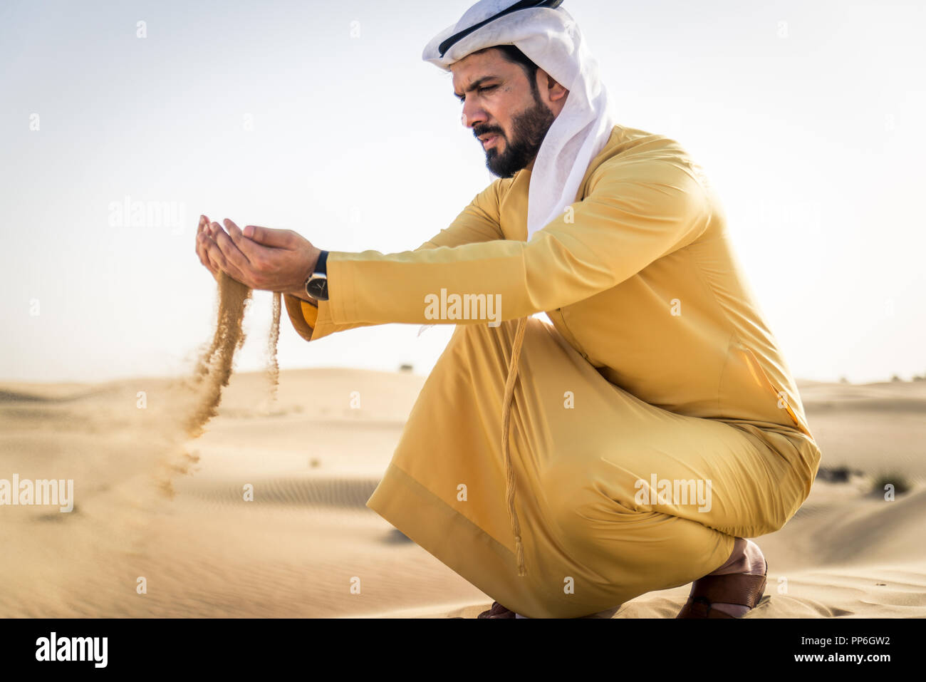 Handsome arabian man with traditional dress in the desert of Dubai ...