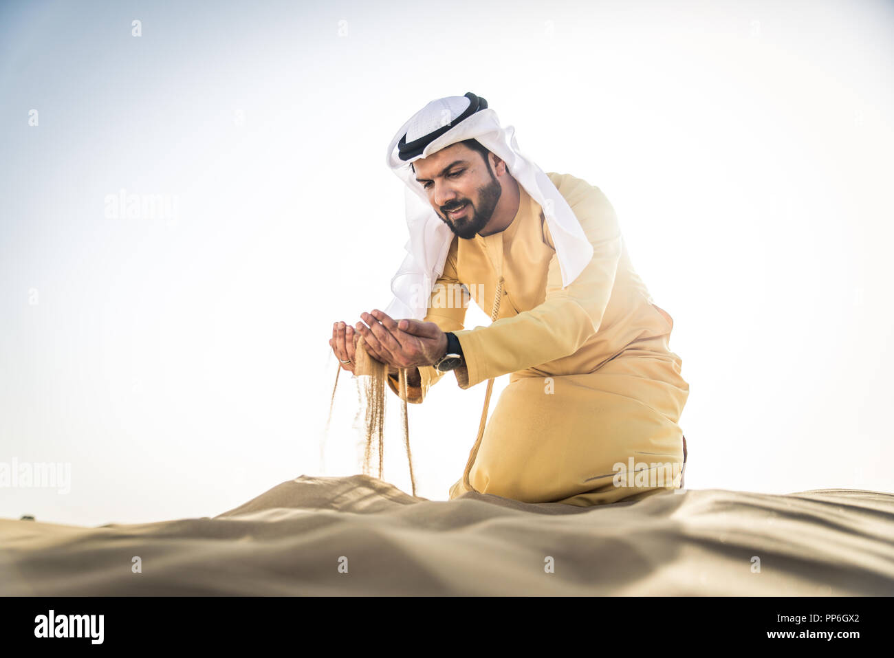 Handsome arabian man with traditional dress in the desert of Dubai ...
