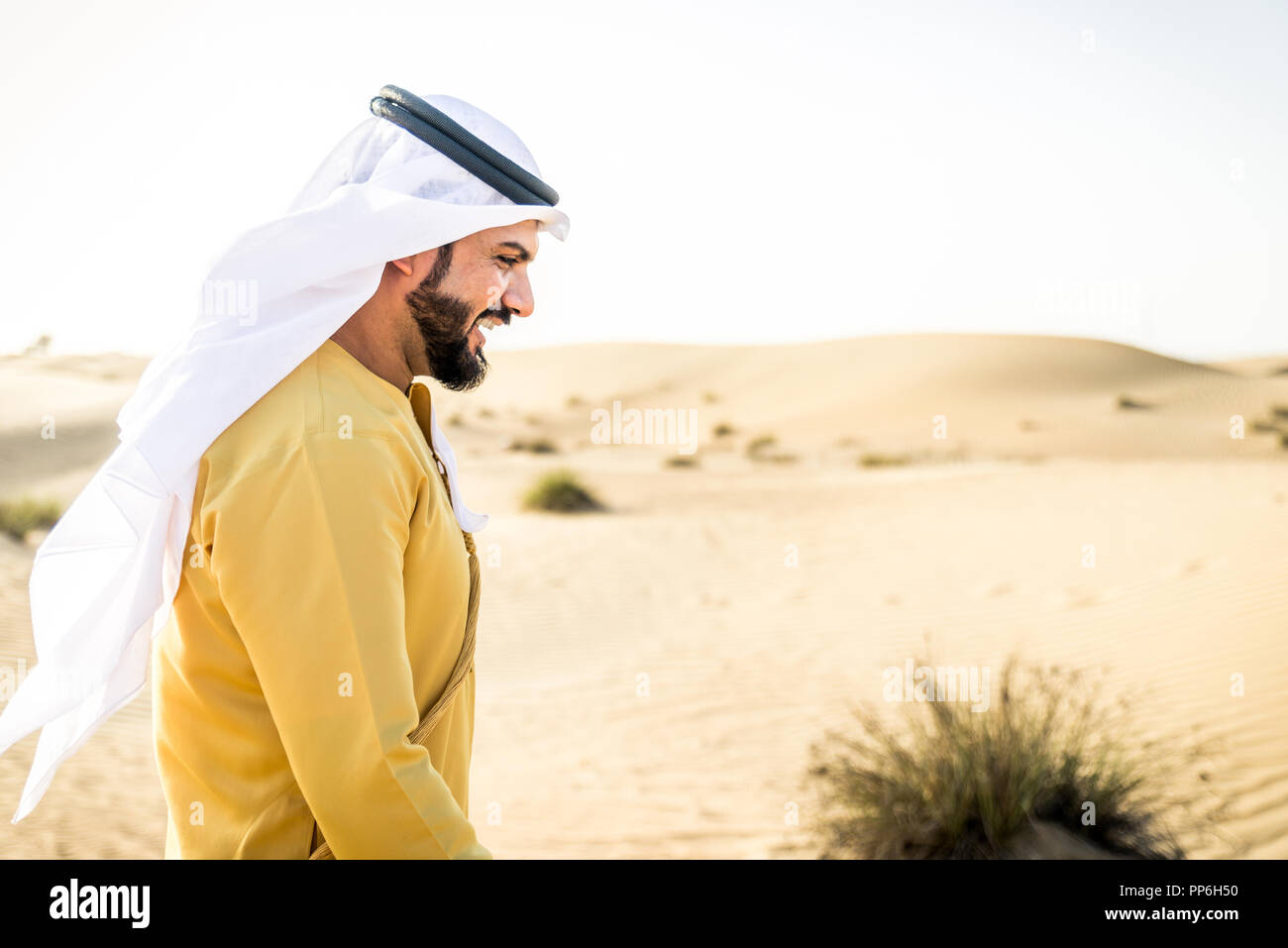 Handsome arabian man with traditional dress in the desert of Dubai ...
