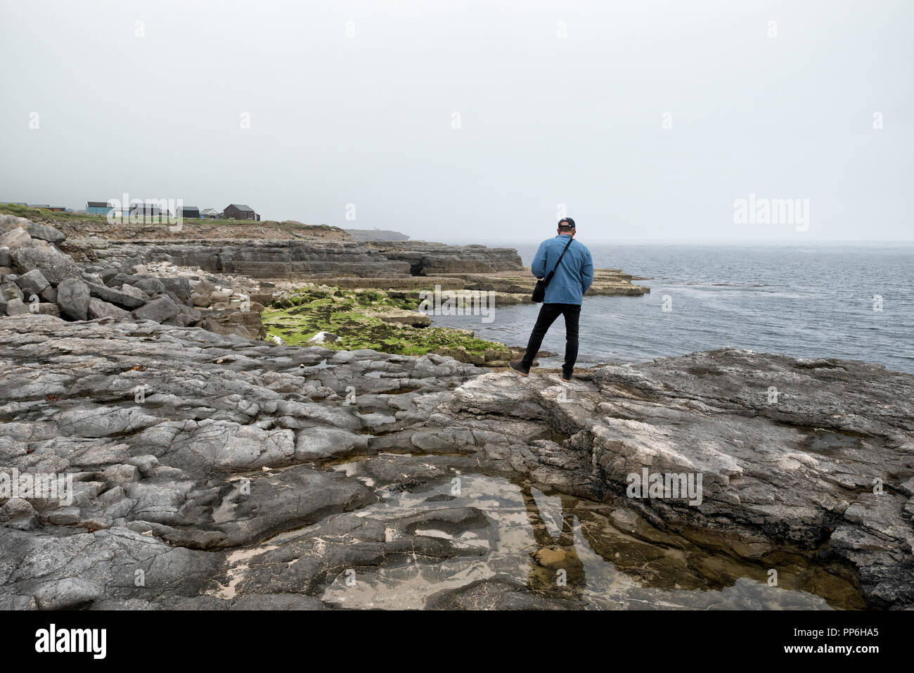 Man watching the view in Portland Bill Stock Photo - Alamy