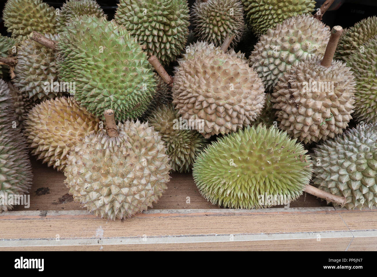 Bunch of durian fruits lying on a market stall table seen from the ...