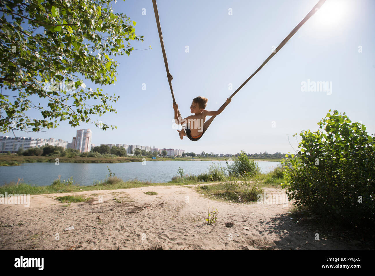 A child is riding on a rope village swing Stock Photo - Alamy