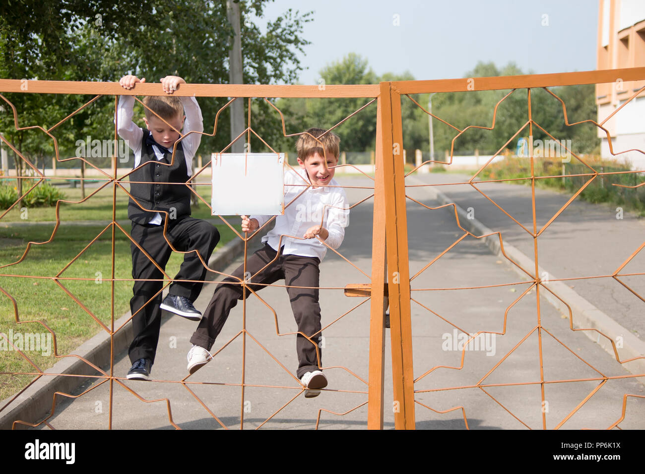 Boys climb over the fence Stock Photo - Alamy