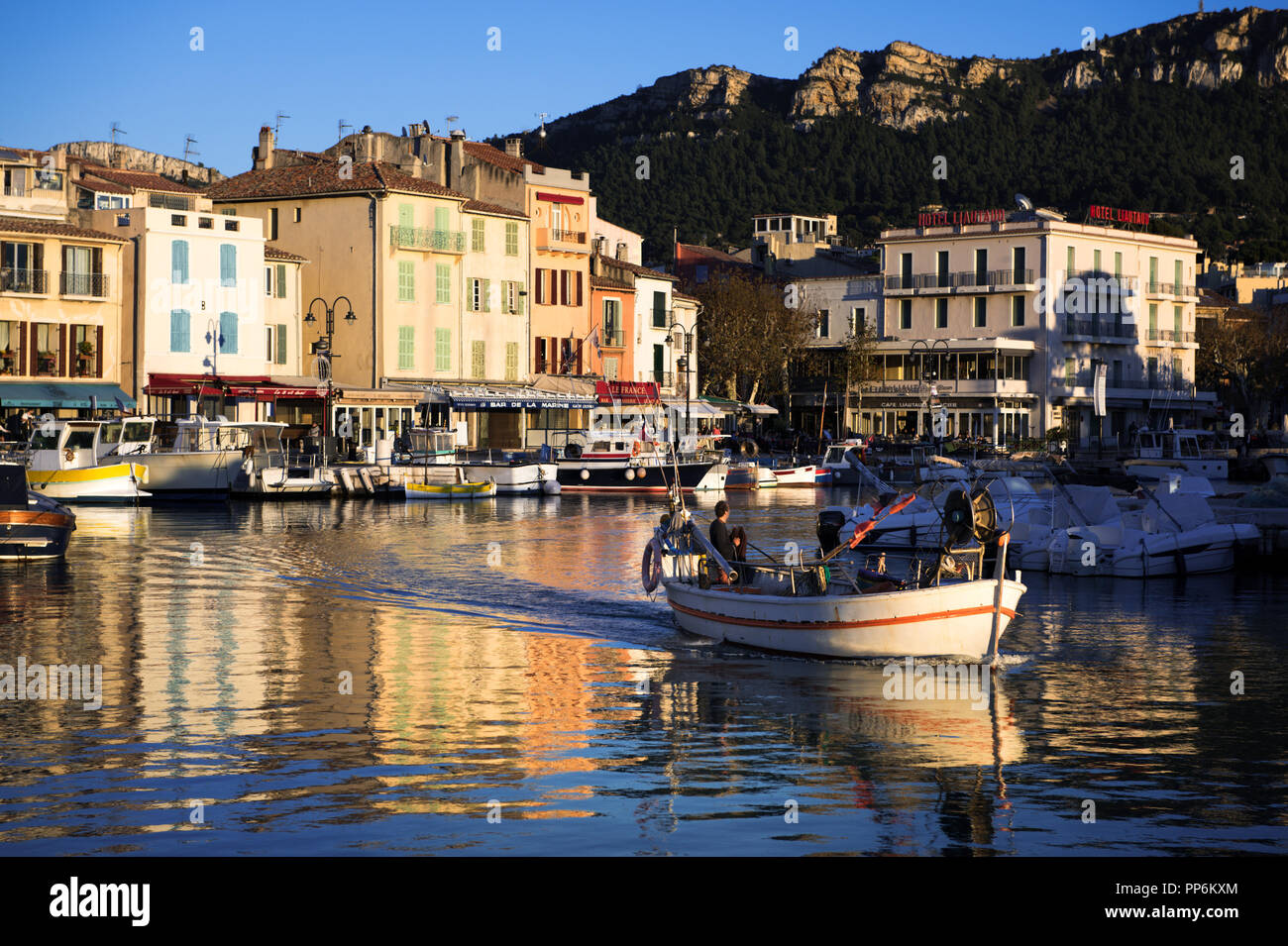 Fisher boat leaving tranquil harbor of ancient Cassis in France in ...