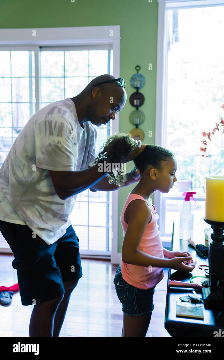 Dad fixing daughter's hair Stock Photo - Alamy