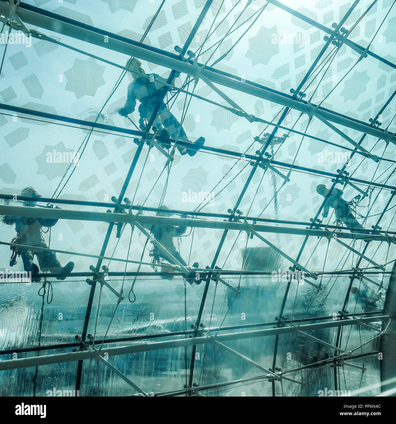 Window cleaners on the outside of curved airport windows, Dubai Airport ...