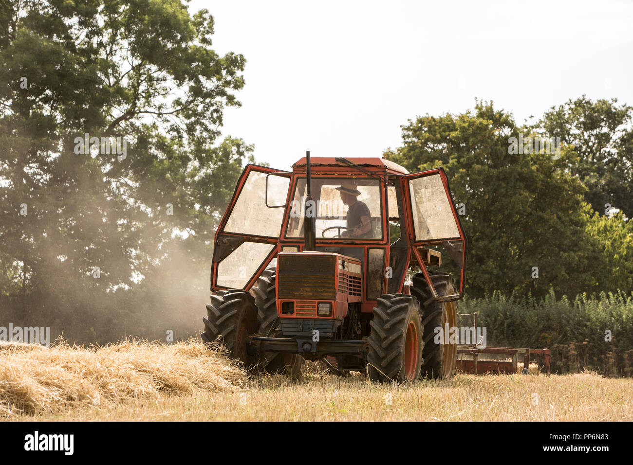 Tractor and straw baler in wheat field, farmer baling straw Stock Photo ...