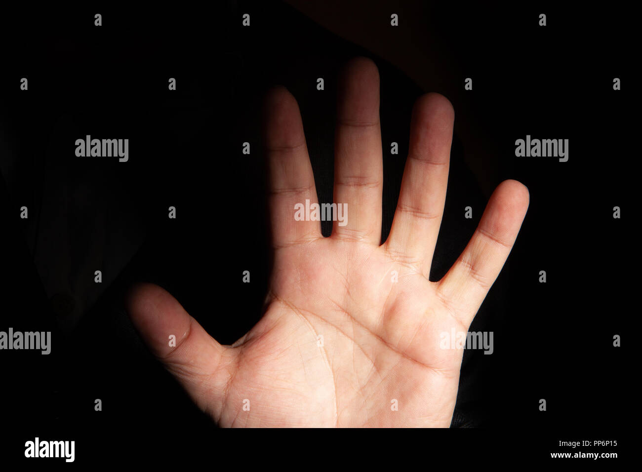 Human hand is drawn by light on a black background, power concept, stop ...
