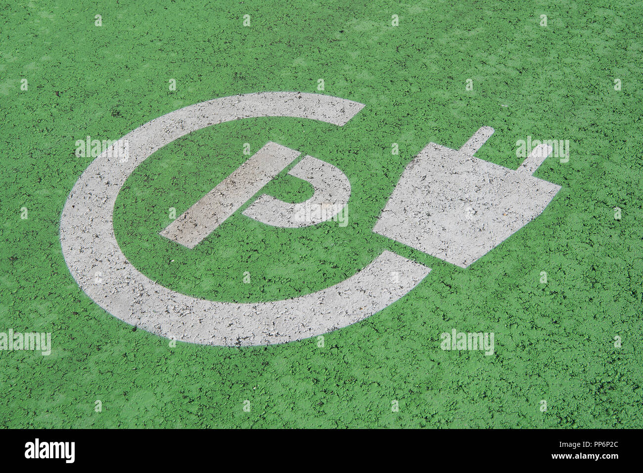 Green sign for charging place for electric cars in a parking lot on ...
