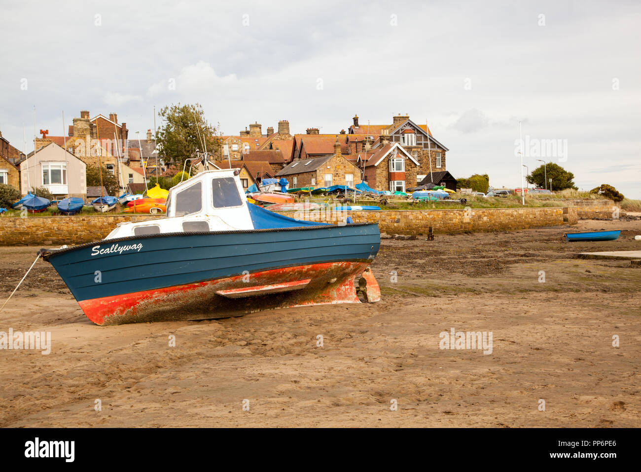 Small fishing boats on the beach at low tide in the Aln estuary at the ...
