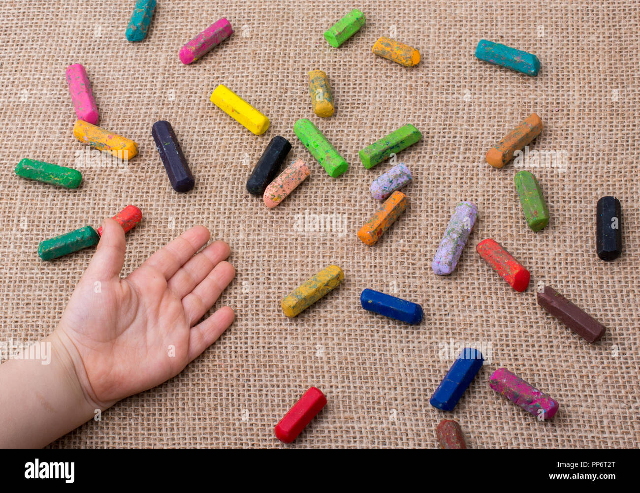 Used color crayons and a toddlers hand on canvas Stock Photo - Alamy