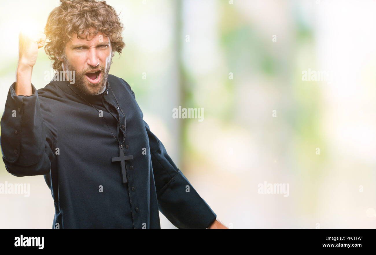 Handsome hispanic catholic priest man over isolated background angry ...