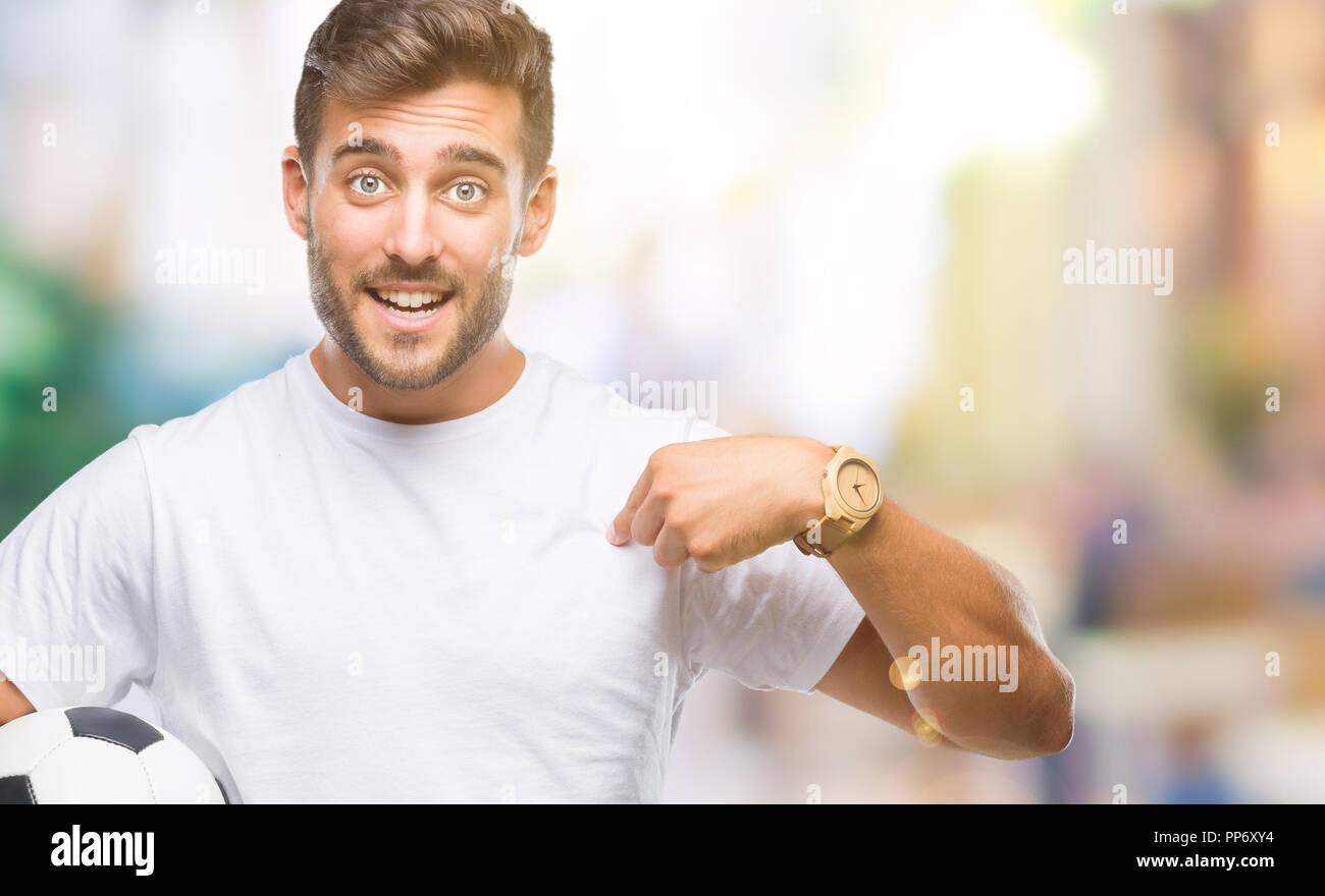 Young handsome man holding soccer football ball over isolated ...