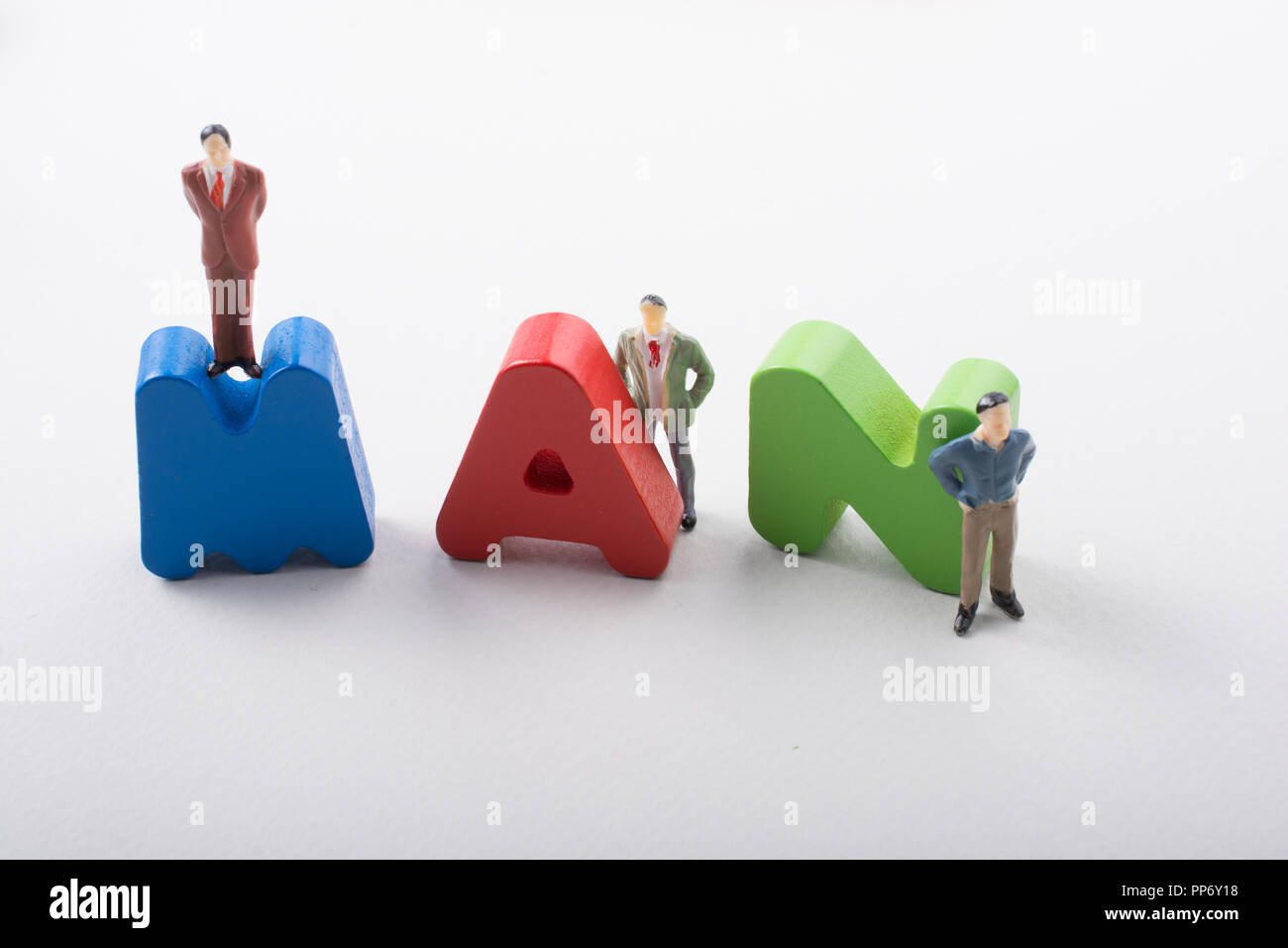 Tiny figurine of men beside colorful wooden letters say MAN Stock Photo ...