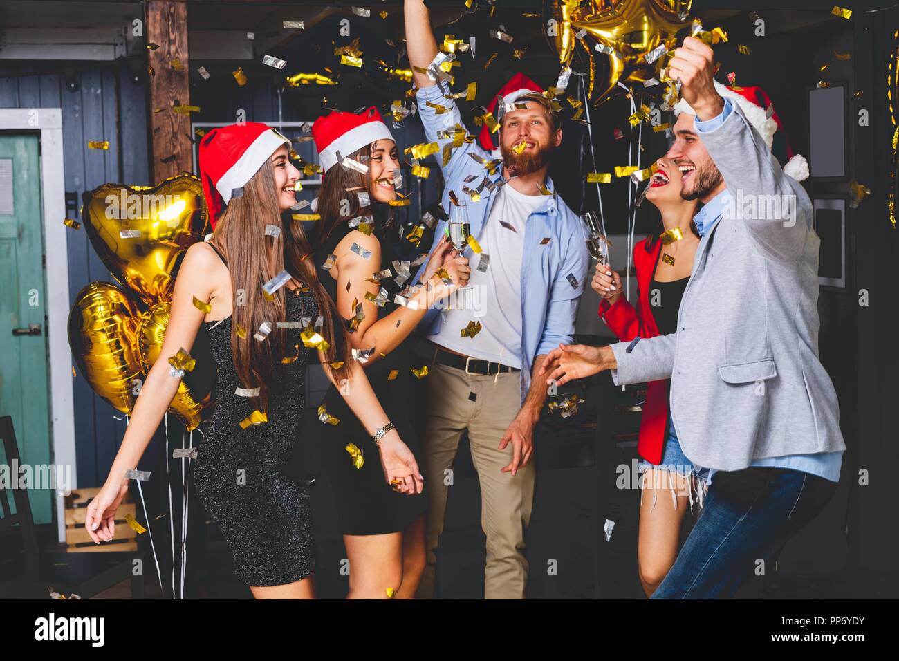 Celebrating New Year together. Group of beautiful young people in Santa ...