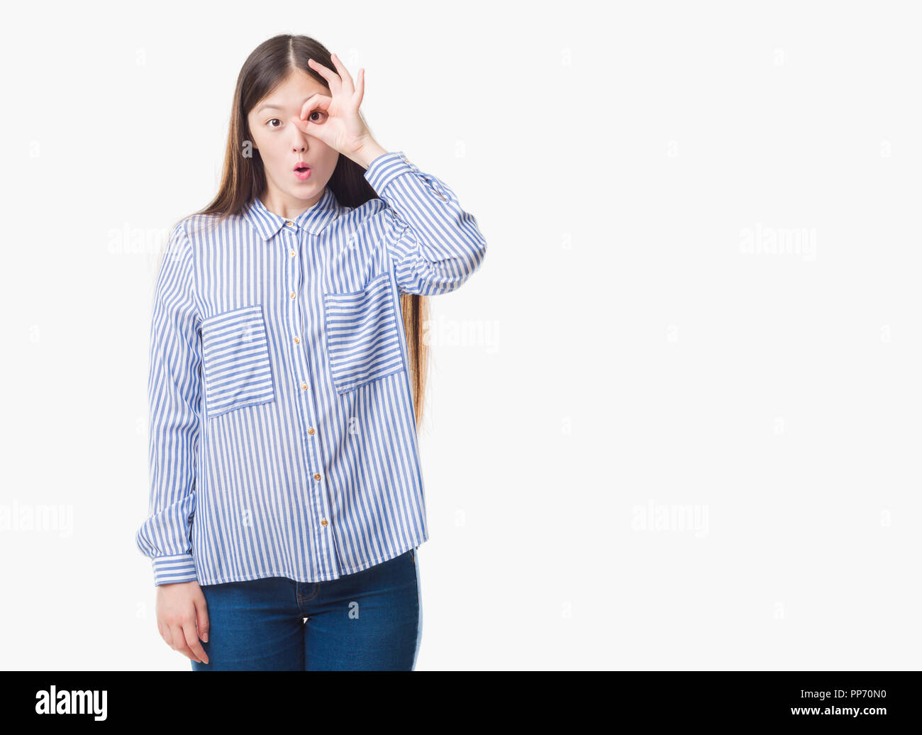 Young Chinese woman over isolated background doing ok gesture shocked ...