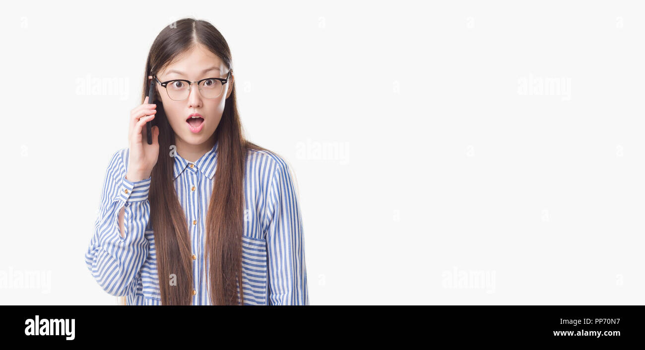 Young Chinese woman over isolated background speaking on the phone ...