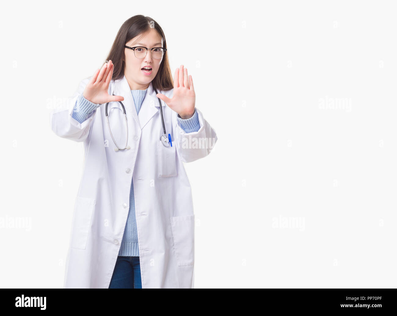 Young Chinese doctor woman over isolated background afraid and ...