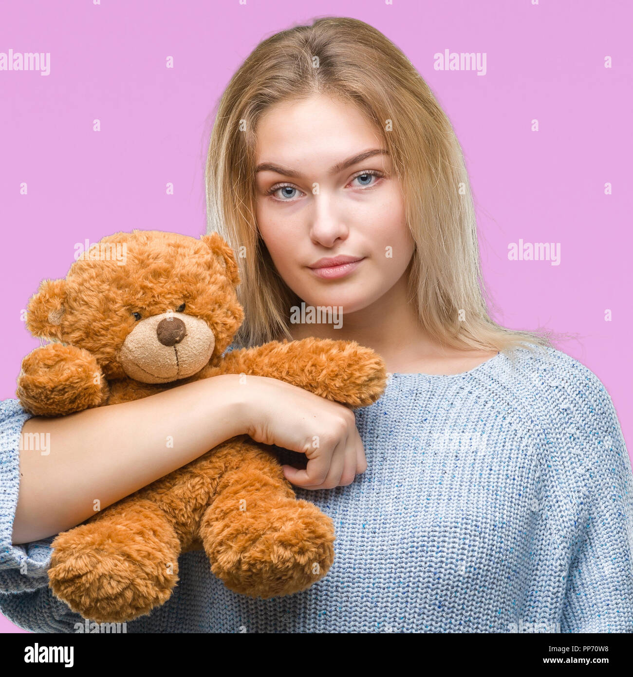 Young caucasian woman holding cute teddy bear over isolated background ...