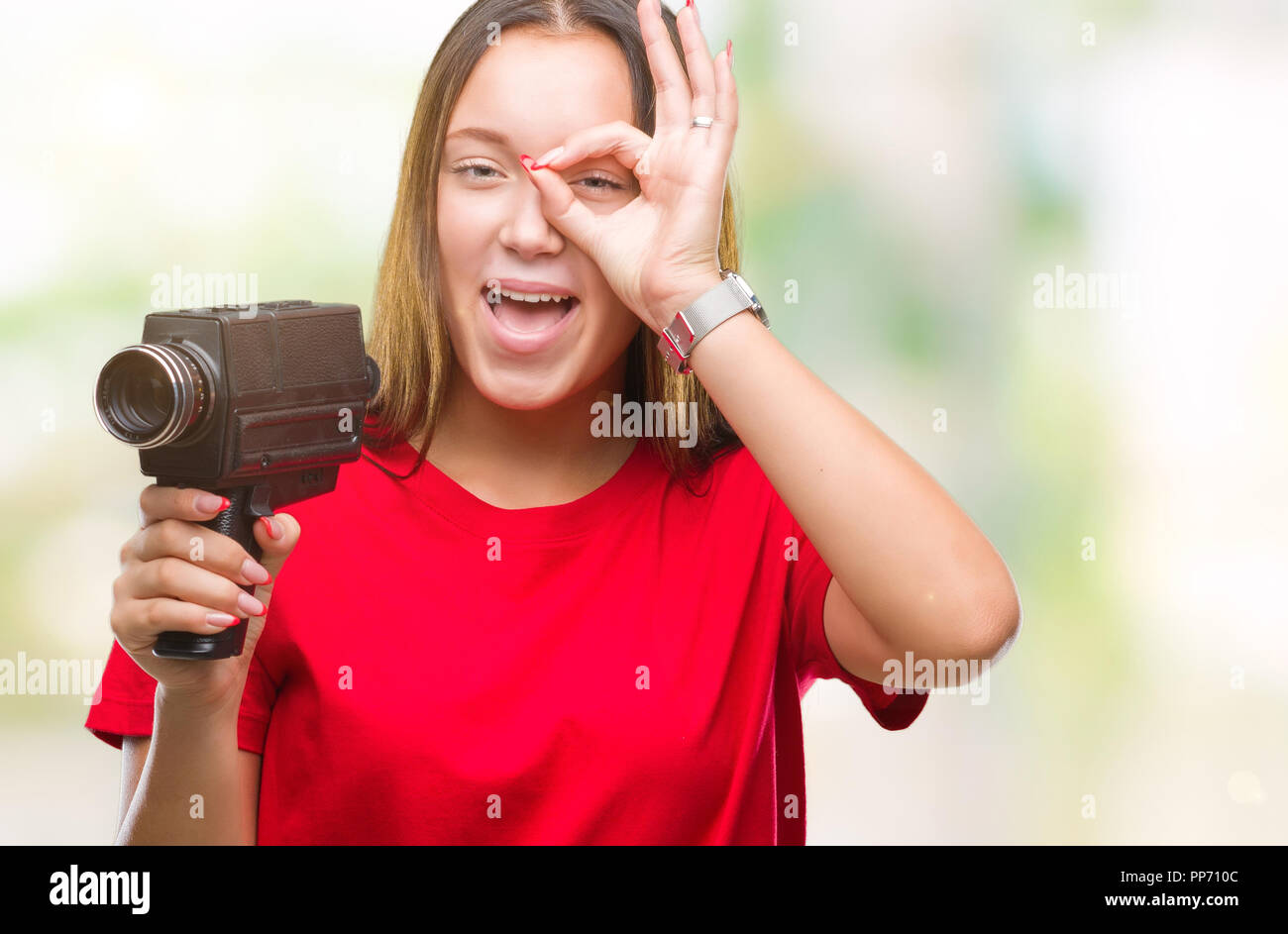 Young beautiful caucasian woman filming using vintage video camera over ...