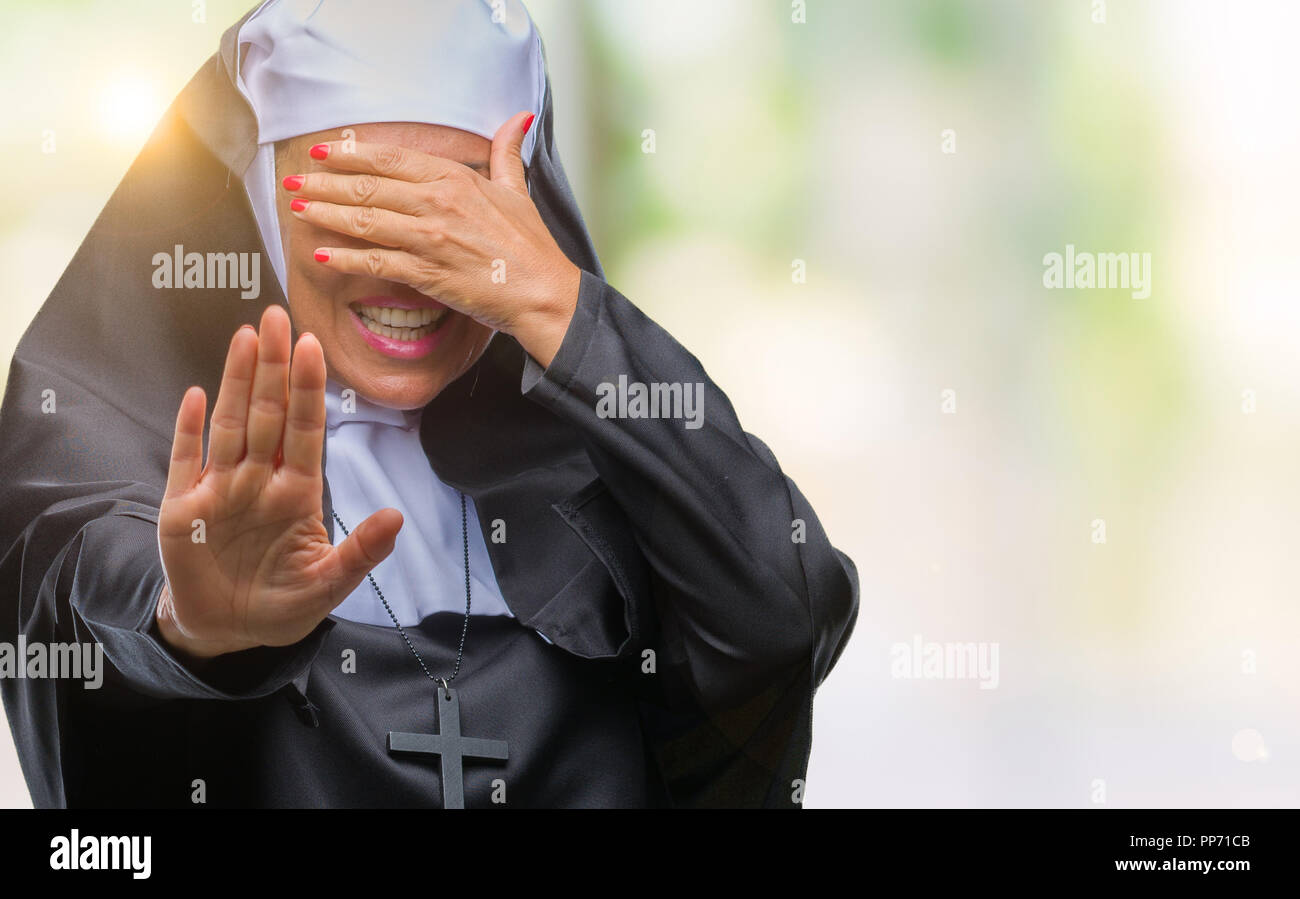 Middle age senior christian catholic nun woman over isolated background ...