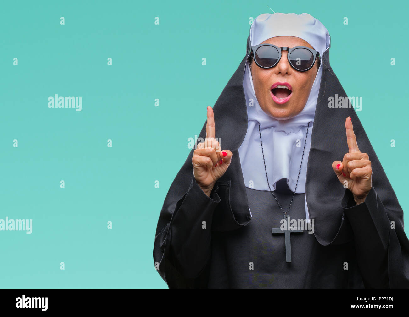 Middle age senior catholic nun woman wearing sunglasses over isolated ...