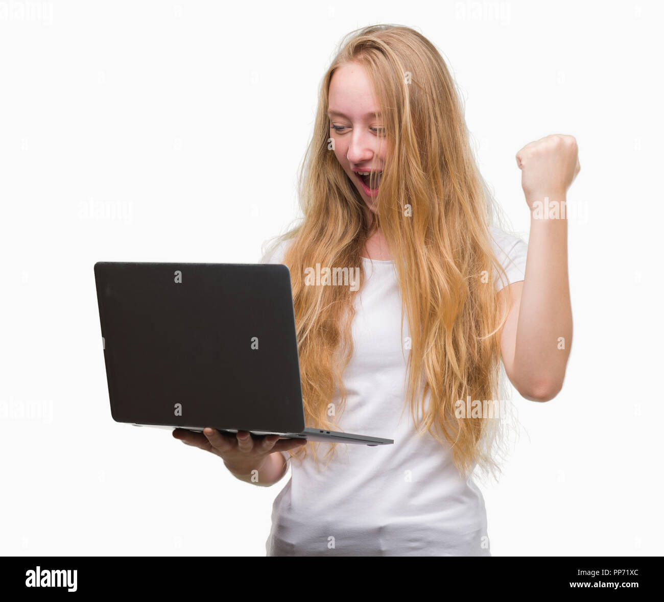 Blonde teenager woman using computer laptop annoyed and frustrated ...