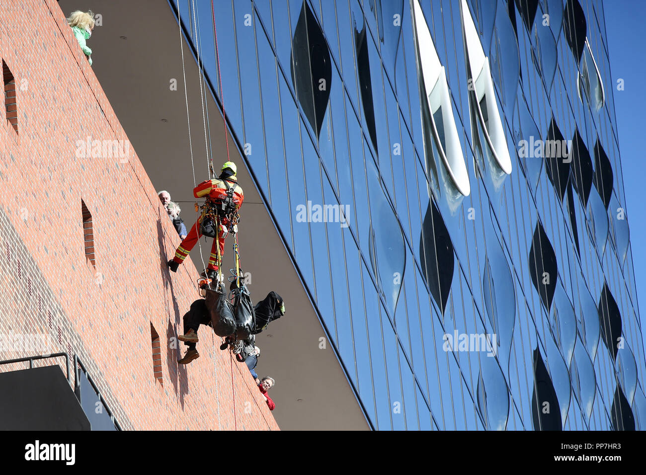 24 September 2018, Hamburg: A height rescuer and a window cleaner hang ...