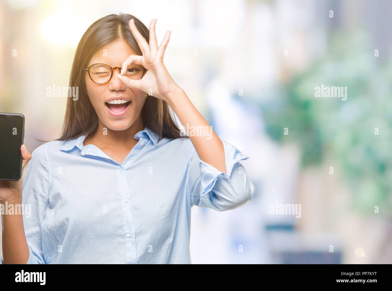 Young asian woman showing smartphone blank screen over isolated ...