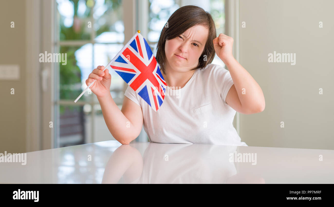 Down syndrome woman at home holding flag of uk annoyed and frustrated ...